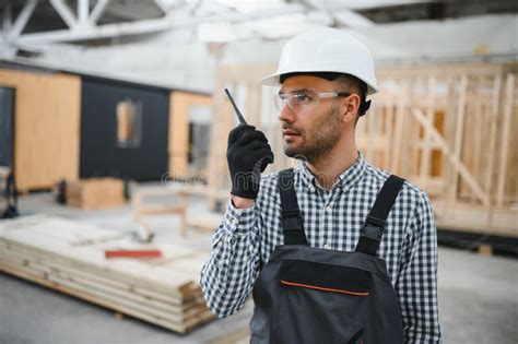 An Engineer Controls The Production Of Modular Houses And Uses A Walkie