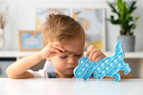 Menino Brincando Com Pop It Fidget Em Casa Foto Grátis
