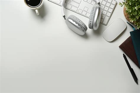 평평하게 누워 무선 헤드폰 커피 한 잔 흰색 사무실 책상에 키보드가 있습니다 텍스트를 위한 공간을 복사합니다 0명에 대한 스톡