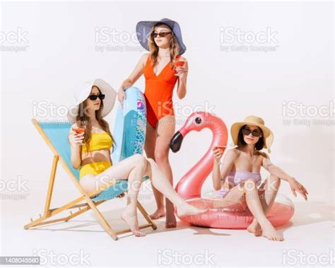 수영복을 입은 세 명의 쾌활한 여성이 여름 모임 수영 회색 배경에 고립 된 칵테일을 마시는 18 19세에 대한 스톡 사진 및