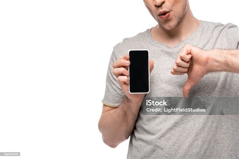 흰색에 격리 된 빈 화면으로 스마트 폰을 들고있는 동안 엄지 손가락을 보여주는 사람의 자른 보기 T 셔츠에 대한 스톡 사진 및