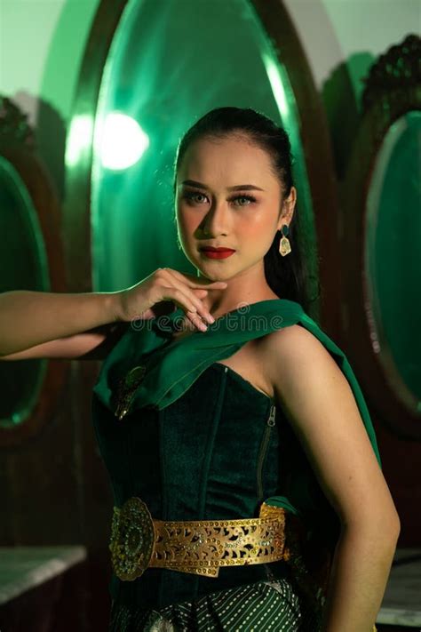 An Asian Female Dancer With A Green Dance Costume And A Body Posing