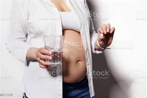 임신 중에 복용할 비타민과 미네랄이 담긴 물 한 잔과 의료용 알약을 들고 있는 클로즈업 임산부 엽산에 대한 스톡 사진 및 기타 이미지 Istock