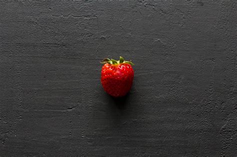 검은 색 어두운 콘크리트 배경에 하나의 빨간색 아름다운 딸기 클로즈업 Minimalism 플랫 레이 맨 위 보기 텍스트에 대한