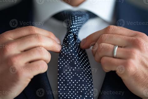 Businessman Adjusting His Tie While Wearing A Formal Suit 50952285