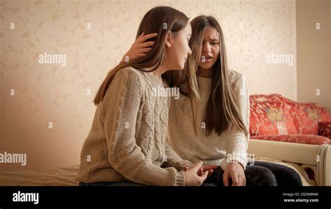 Teenage Girl Consoling And Comforting Her Friend Talking About Her