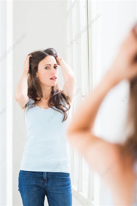 Woman Checking Her Face In The Mirror Stock Image C0352097