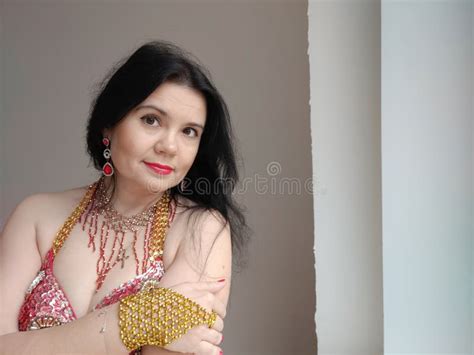 A Dancer In A Red Suit Is Dancing An Oriental Dance On A White
