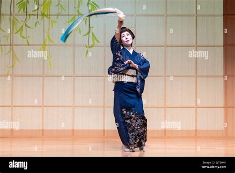 A Japanese Geisha Wearing A Kimono Performs A Traditional Dance Called