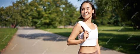 Free Photo Smiling Asian Fitness Girl Holding Towel On Shoulder