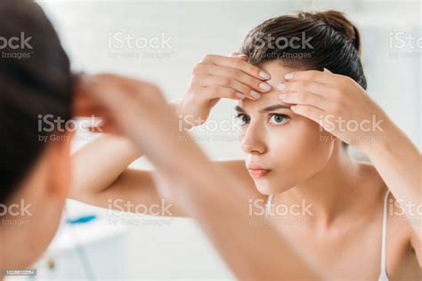 얼굴 피부를 확인 하 고 욕실에서 거울을 보고 젊은 여자의 선택적 초점 가정 생활에 대한 스톡 사진 및 기타 이미지 가정