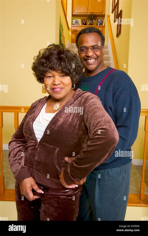 An African American Middle Class Couple Pose In Their Living Room In