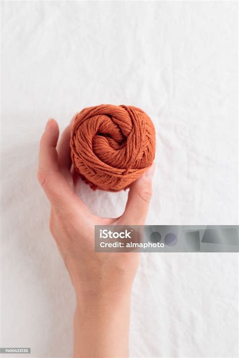 Kait Rajutan Dan Bola Warna Oker Benang Katun Di Tangan Di Atas Meja