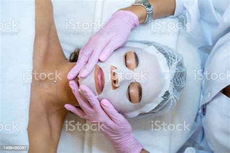 전문 의사 미용사가 고객의 얼굴에 시트 마스크를 바르고 에스테틱 클리닉에 있는 여성 25 29세에 대한 스톡 사진 및 기타 이미지 25 29세 2명 가꿔주기 Istock