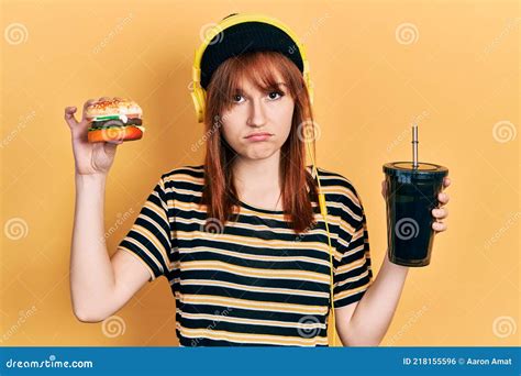 Joven Pelirroja Comiendo Una Hamburguesa Y Bebiendo Refresco Usando