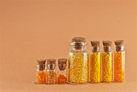 밝은 주황색 배경에 유리 항아리에 노란색과 빨간색 구슬 나무 코르크투명 용기에 구슬 질서 균형과 혼돈의 개념 0명에 대한 스톡 사진 및 기타 이미지 Istock