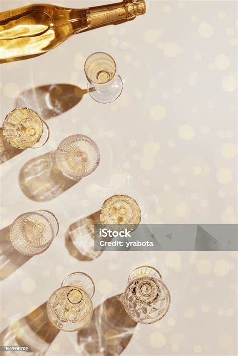 흰색 스파클링 와인 병으로 평평하게 누워 햇빛 그림자가 있는 안경 와인을 설정하고 밝은 베이지색 배경에 플레어를 설정합니다 화이트 와인 미적 사진 복사 공간 여름 휴가 흑백