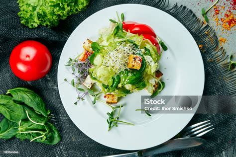 토마토 두부 치즈 화이트 플레이트에 마이크로 그린채식 샐러드 회색 천 상단보기에 샐러드와 구성 건강한 음식 0명에 대한 스톡