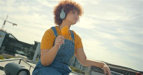 여성 아이스크림 및 음악 헤드폰 도시 여행 장소 또는 여름 휴가 및 스피커 오디오 장비 또는 간식 생각 관광객 및 학생은 롤리와 함께 라디오 팟 캐스트 또는 노래를 듣고