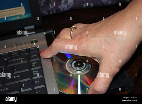 Inserting CD By Womans Hand Stock Photo Alamy
