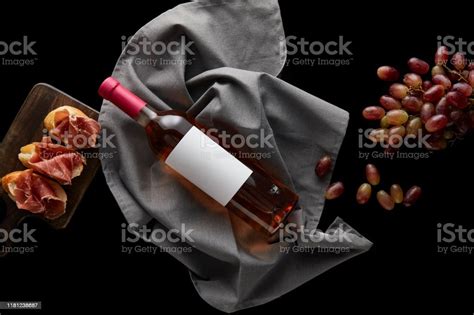 잘 익은 포도 근처 회색 냅킨에 빈 흰색 라벨장미 병의 상단보기와 검은 색에 고립 된 바게트에 슬라이스 Prosciutto 접시 타월에 대한 스톡 사진 및 기타 이미지