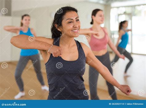 Cheerful Hispanic Woman Practicing Vigorous Dance In Group Class Stock