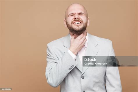 목 구멍 통증 또는 감기입니다 서와 그의 고통 스러운 목 감동 빛 회색 양복에 닫힌된 눈으로 중간 세 대머리 수염된 사업가의