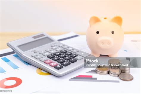 돼지 저금통과 계산기 옆에 있는 동전 더미에는 재무 계획의 개념이 있습니다 돈과 재정 개념을 절약합니다 성장 경제 비즈니스 및 투자에 대한 아이디어 은행 투자 걱정하는에