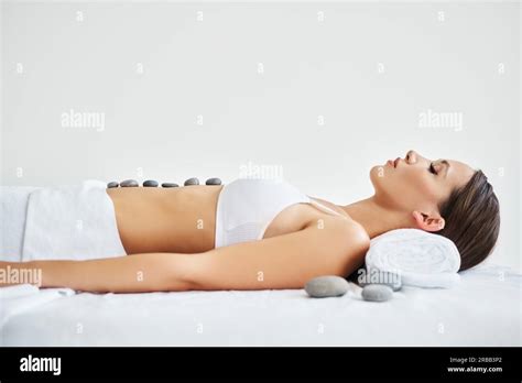 Young Woman Relax Lying On Massage Couch With Spa Stones On Her Abdomen Therapy Beauty