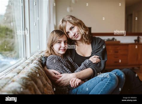 Portrait Affectionate Mother And Daughter Cuddling On Living Room Sofa