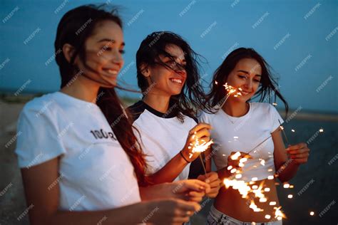 Premium Photo Sparklers In The Hands Of Young Girls On Beach Three