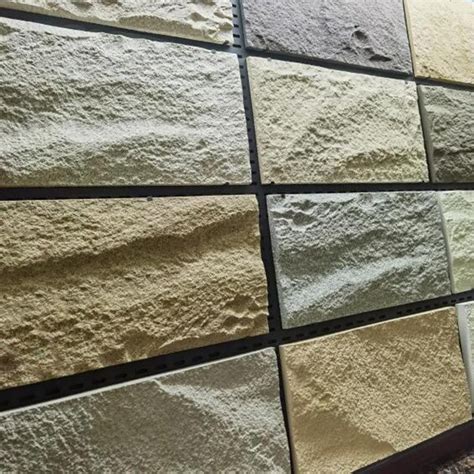 A Wall Made Up Of Different Colors And Sizes Of Stone Tiles With Plants