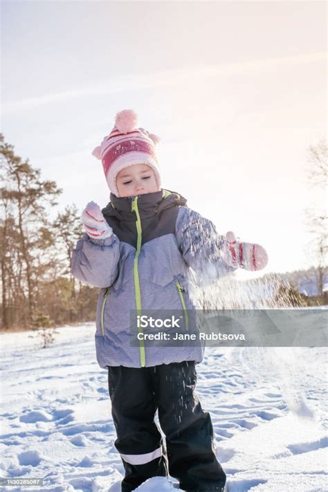 겨울 옷 작업복 모자 및 장갑을 입은 34 세의 어린 소녀는 야외에 서서 눈을 비웃고 있습니다 세로 겨울에 대한 스톡 사진 및 기타 이미지 Istock