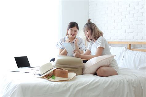 듀오 트래블러스 컨셉 두 명의 여성이 여행을 준비하고 있습니다 여름 방학에 가는 소녀 두 여자 친구는 스마트 폰과 노트북을 들고 온라인 투어를 예약합니다 2명에 대한 스톡