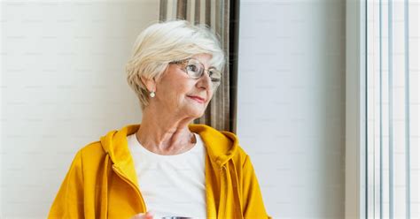 창가에 있는 선배 여성이 커피나 차 한 잔을 들고 있다 감염을 예방하기 위해 격리 된 노인 여성 창문을 통해 보고 있는 늙은 여자 사진 Unsplash의 세르비아 이미지