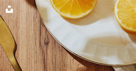 나무 테이블 위에 얇게 썬 오렌지를 얹은 하얀 접시 사진 Unsplash의 무료 음식 이미지