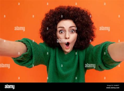 Portrait Of Shocked Woman With Afro Hairstyle Wearing Green Casual