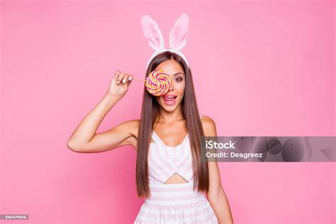 아름 다운 사랑 스러운 화려한 매력적인 좋은입고 긴 머리를 가진 배가 여자 사람 그녀 원형 사탕 숨기기 커버 눈 스탠드 핑크 파스텔 빛 배경 흰 줄무늬 착용에 고립 된