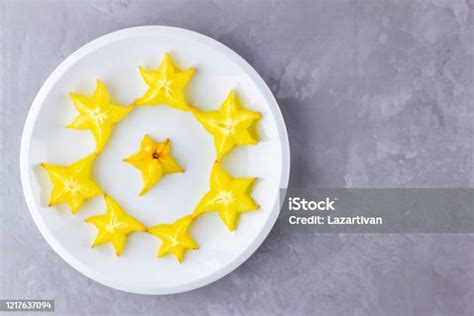 흰색 접시에 카람볼라 회색 배경에 신선한 카람볼라를 슬라이스 스타 과일 의 조각 트렌디 한 음식 복사 공간 0명에 대한 스톡