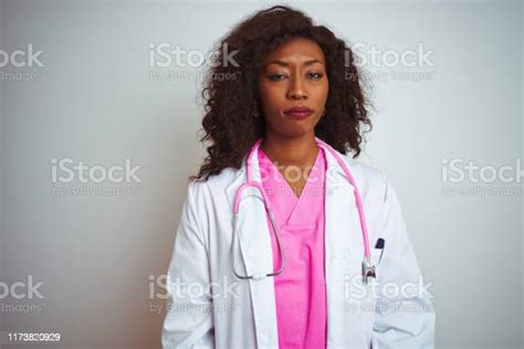 고립 된 흰색 배경 위에 분홍색 청진기를 입은 아프리카 계 미국인 의사 여성은 우울하고 고민에 대한 걱정 분노와 두려움을 울고 슬픈 표정 감정에 대한 스톡 사진 및 기타