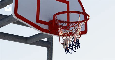 배경에 푸른 하늘이 있는 빨간색과 흰색 농구 골대 사진 Unsplash의 무료 모바일용 배경 화면 이미지