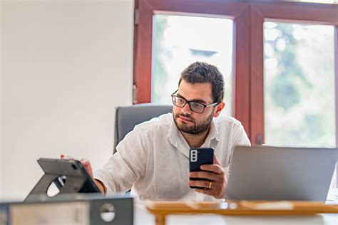 사무실 책상에서 디지털 태블릿과 스마트폰을 사용하는 사업가 Brand Name Online Messaging Platform에