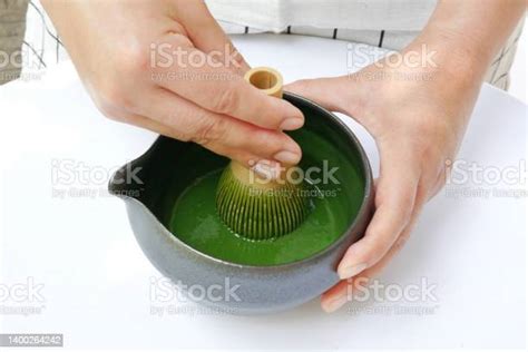 화이트 테이블 그릇에 전통적인 유기농 일본 말차 녹차 분말과 우유 를 준비하고 혼합하는 핸드 홀드 털 마카차에 대한 스톡 사진