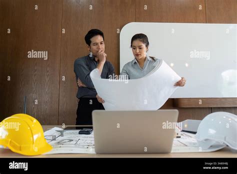 Design And Analysis Engineers Analyzing Blueprints Together For A Construction Project Stock