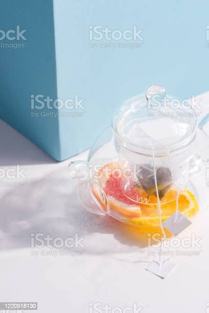 파스텔 블루 벽에 그림자와 흰색 테이블에 유리 투명 찻주전자에 여름 수제 차가운 과일 차 음료 0명에 대한 스톡 사진 및 기타