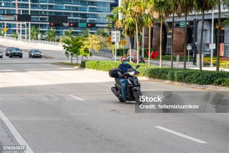 코로나바이러스 코비드 19의 확산을 막기 위해 마스크와 장갑을 착용한 스쿠터를 타고 있는 남자 모터 스쿠터에 대한 스톡 사진 및 기타 이미지 Istock