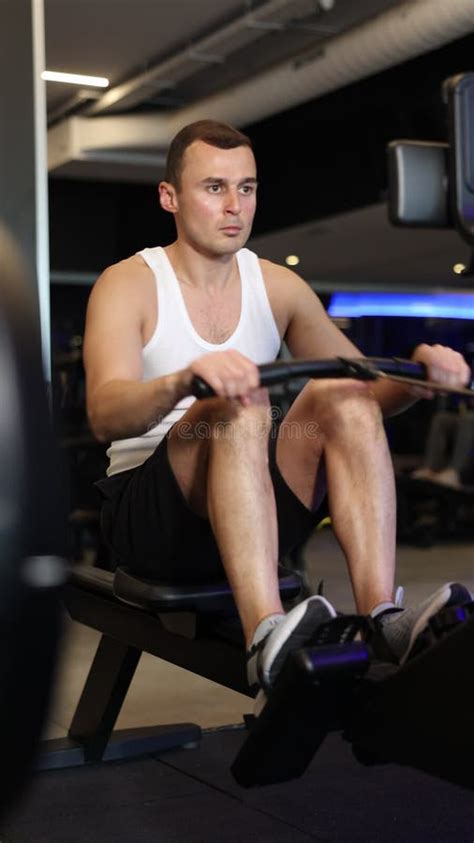 Sportive Young Man Doing Exercises On Cable Rowing Device In Well Equipped Gym Stock Video