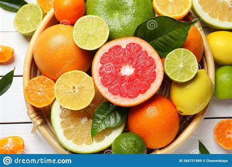 Different Ripe Citrus Fruits With Green Leaves On White Wooden Table