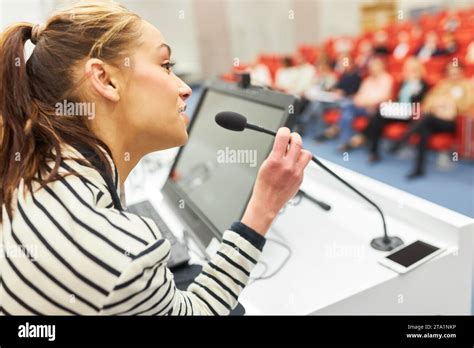 Female Speaker Giving Speech Through Microphone At Stage In Seminar At