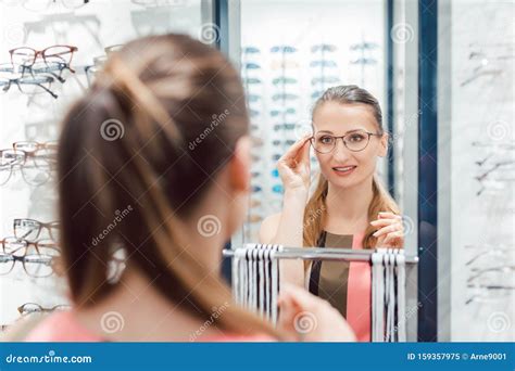 Young Woman Trying Fashionable Glasses In Optometrist Store Stock Image
